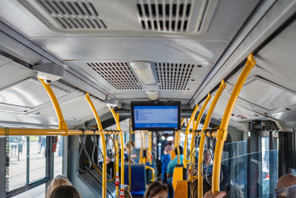 A dynamic urban scene of a group of people in motion on a city bus. The ...