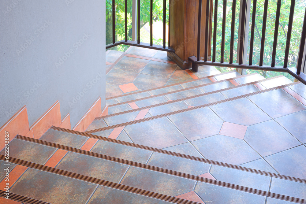 Brown tile steps of interior spiral staircase with steel balustrade ...
