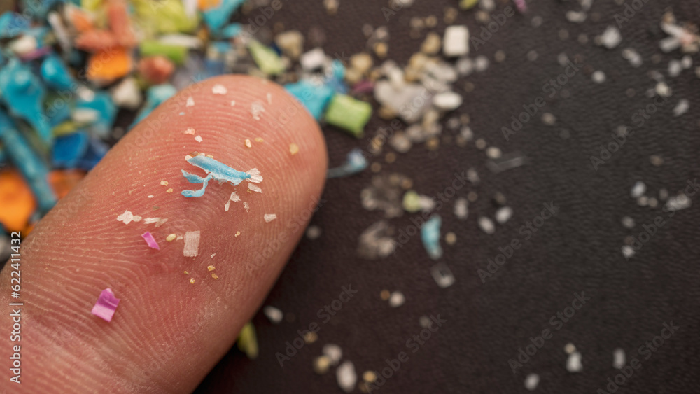 Macro picture of microplastic particles and sand grains on a human ...