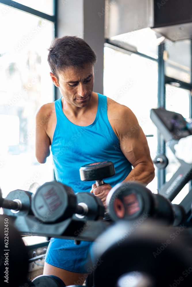 Foto de An adult bodybuilder with an amputated arm is working the ...