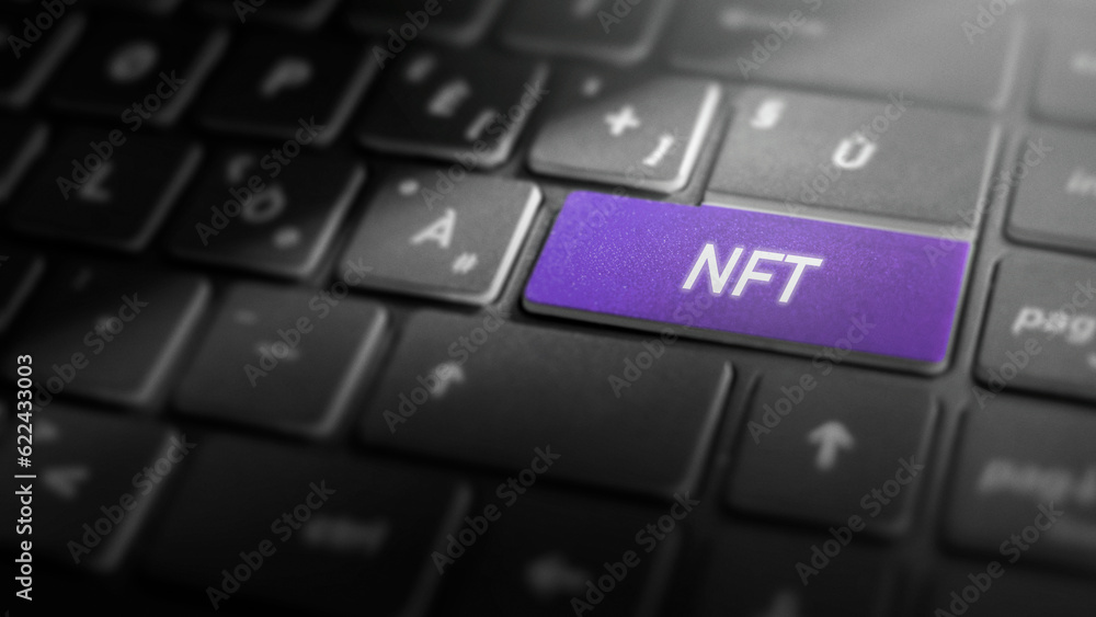 NFT key on laptop computer keyboard, purple button on the dark grey keybord of a modern laptop ...