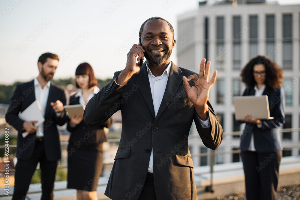 Beaming african american gentleman having conversation on smartphone ...