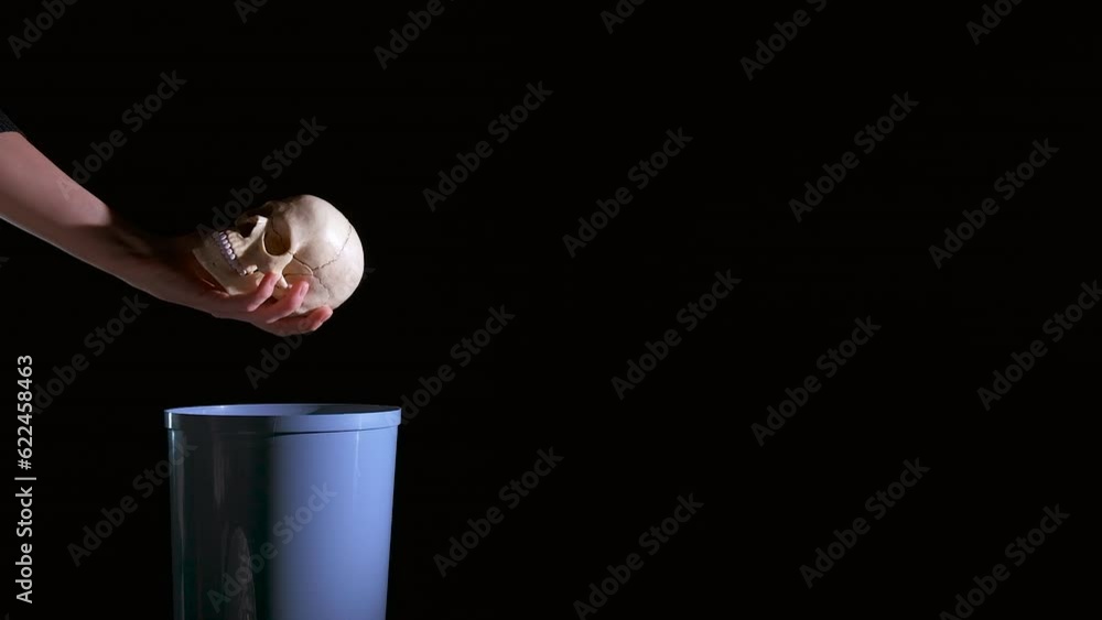 Skull fall away. A person put the human skull into the plastic bin on ...