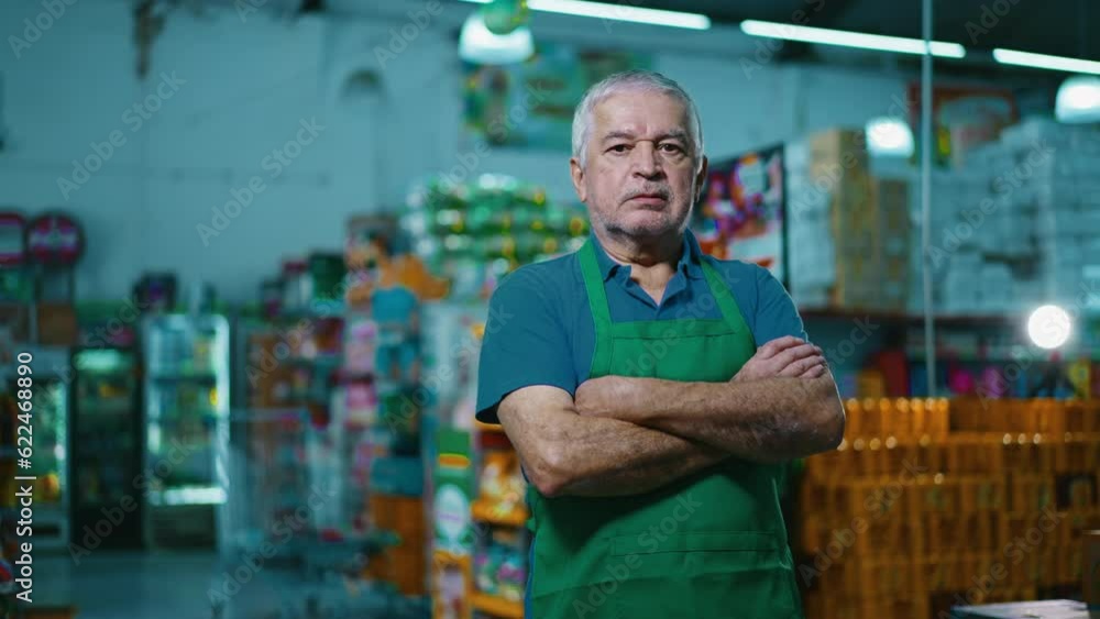 Serious small business owner with arms crossed standing inside Grocery ...