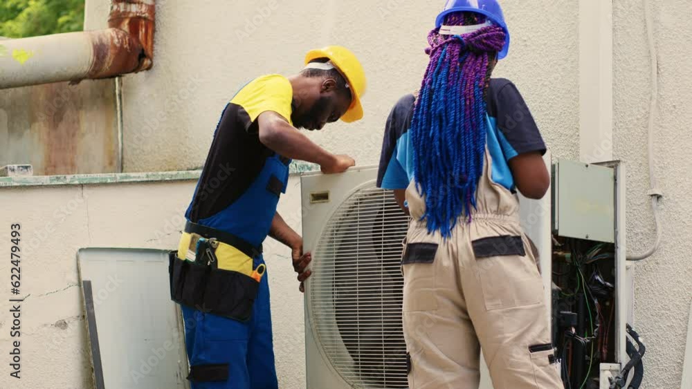 Seasoned mechanic and adept repairman opening up old broken hvac system ...