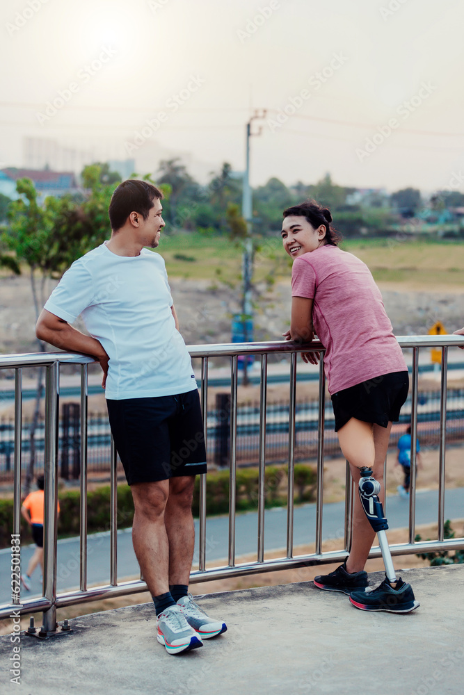 Friend support Friend with a prosthetic leg while exercising outdoor ...