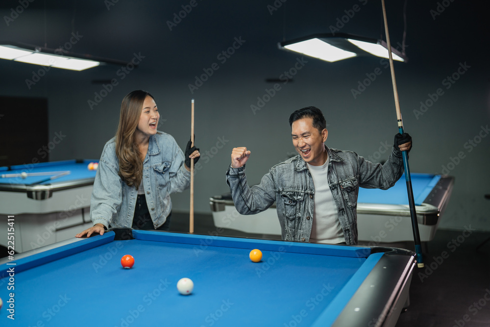 excited male pool player celched his arm and screming happily while ...