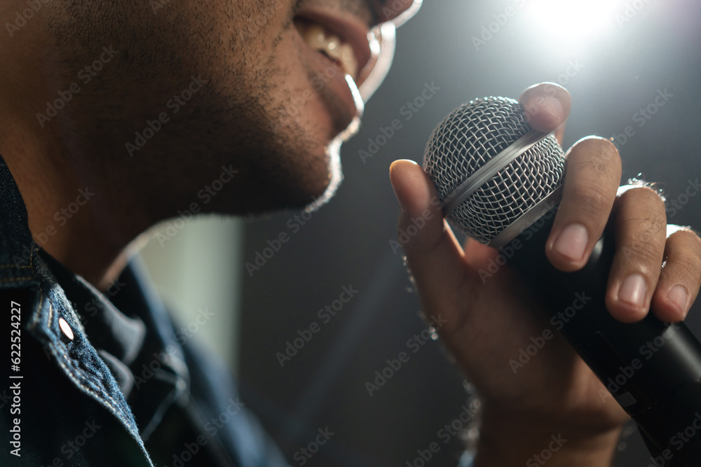 Attractive singer man singing music and playing guitar on stage with ...