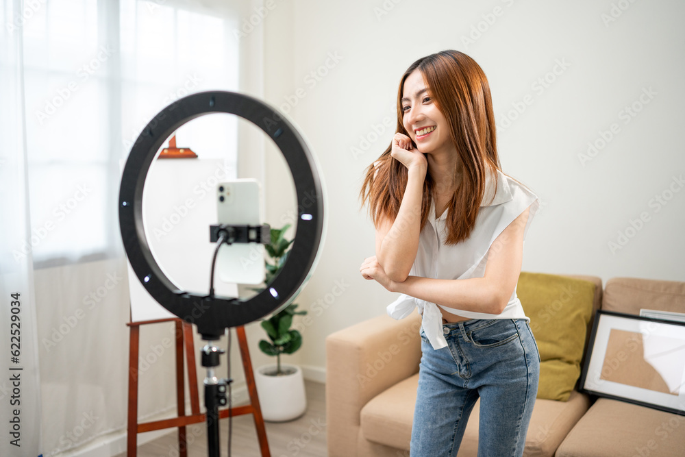 Young trendy influencer asian woman dancing on mobile phone at home in ...