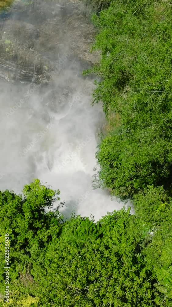 Flying over the waterfalls with beautiful cascades which made a mist ...