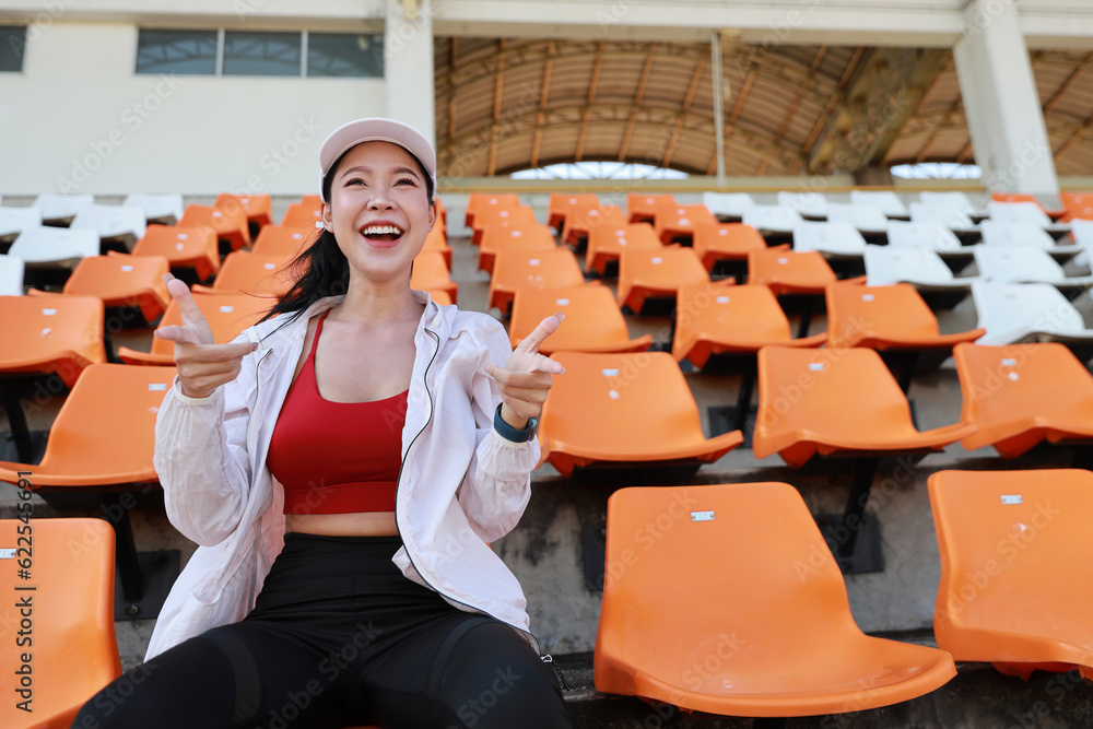 Portrait of happy and excited young female asian sport fan cheering and ...