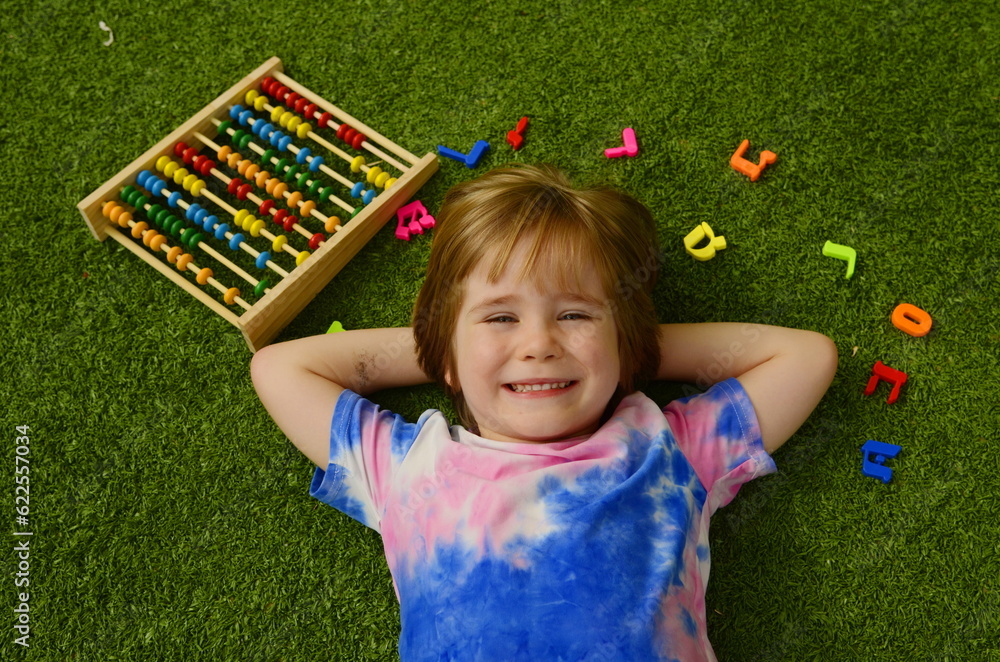 Hebrew alphabet. The boy is learning Hebrew. Multi-colored letters on ...