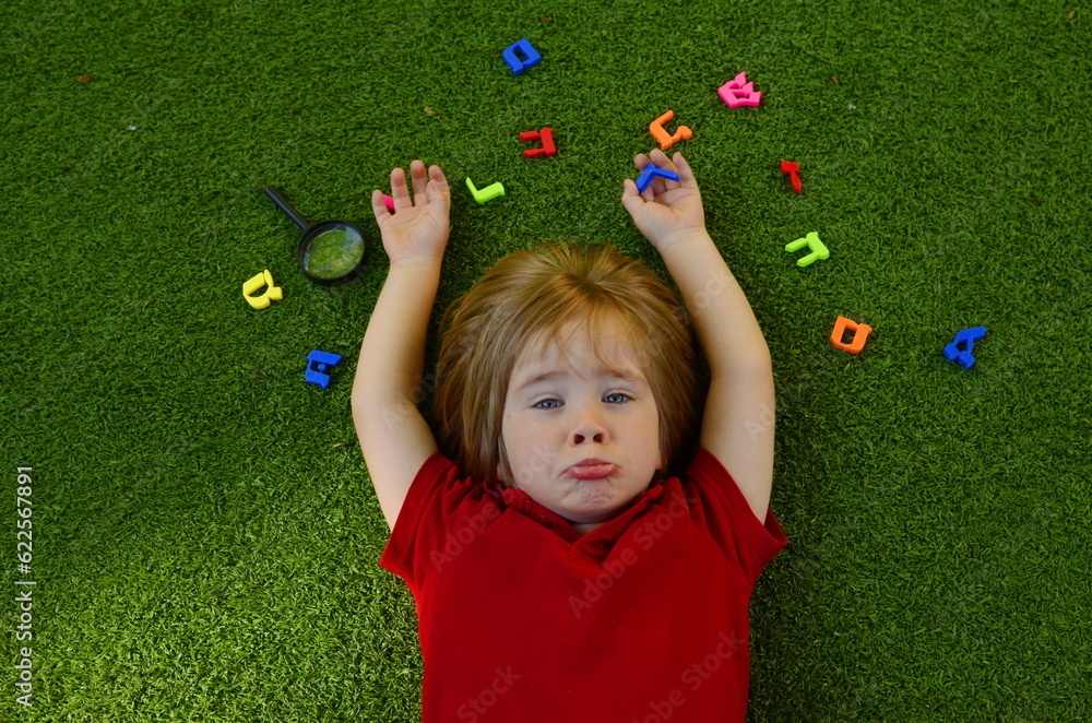 Hebrew alphabet. The boy is learning Hebrew. Multi-colored letters on ...