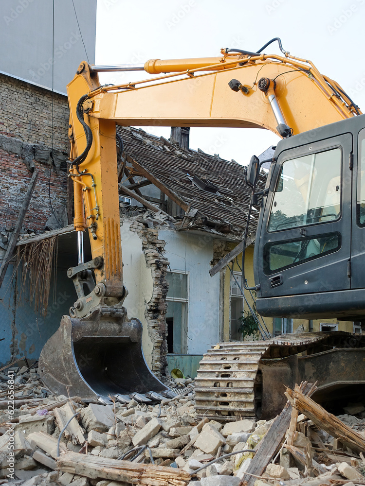 Heavy yellow excavator machine bagger clears the ground where the house ...