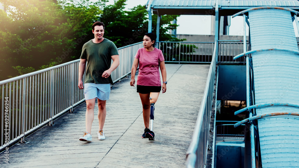 Friend support Friend with a prosthetic leg while exercising outdoor ...