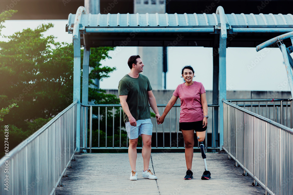Friend support Friend with a prosthetic leg while exercising outdoor ...