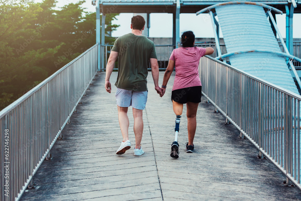 Friend support Friend with a prosthetic leg while exercising outdoor ...