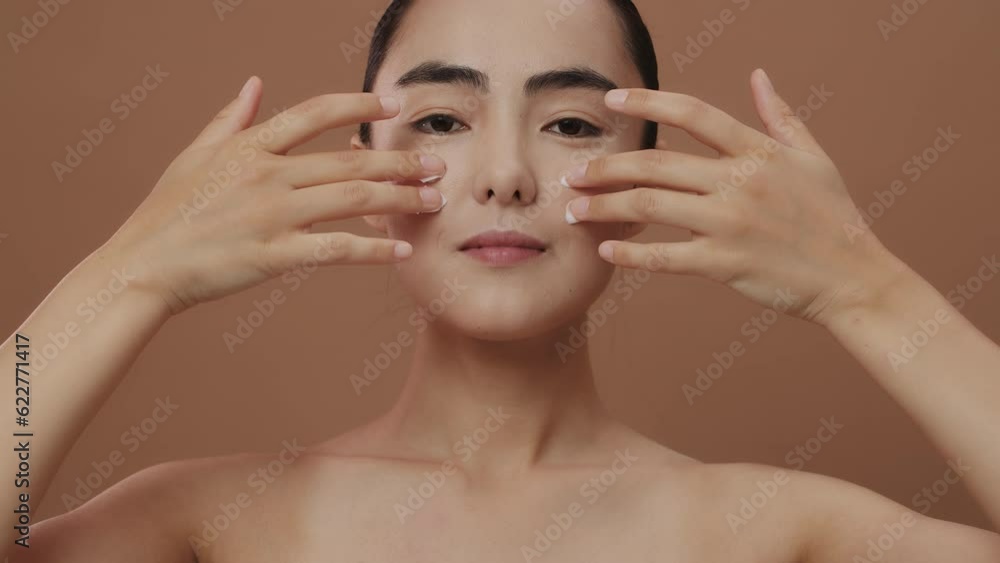 Portrait of a young attractive asian woman with shiny pure skin slowly ...