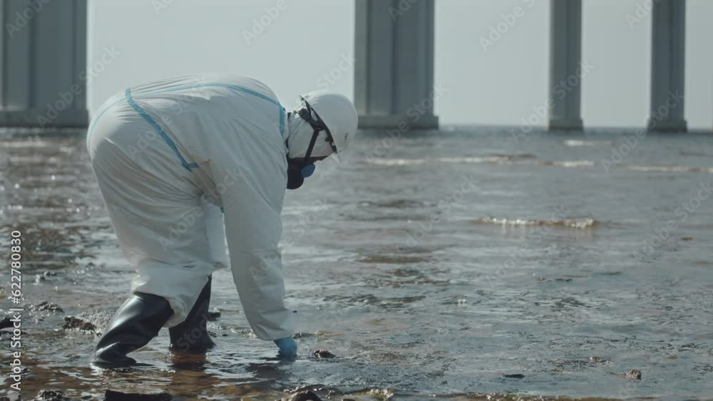 Female ecologist wearing protective coverall, respiratory mask, gloves ...