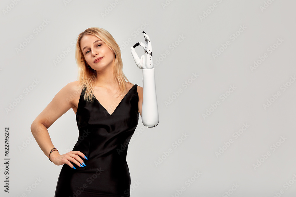 Studio portrait of beautiful young blonde girl with disability wearing ...