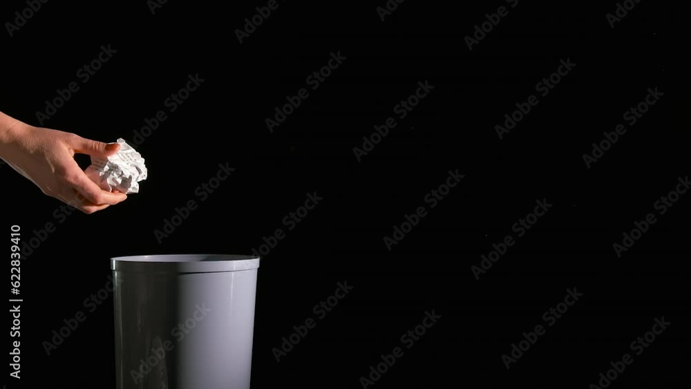 Throw paper balls in bin on black background. An female officer hand ...
