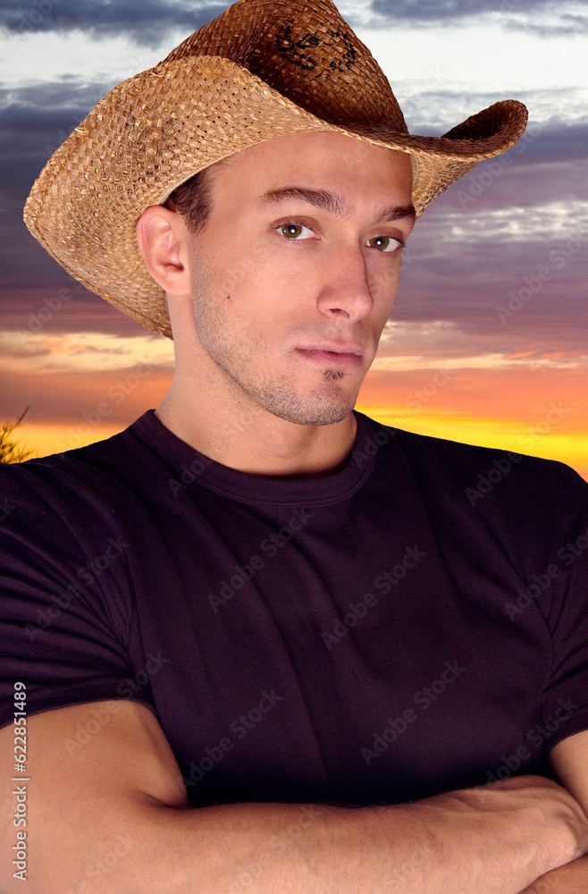A hot-looking cowboy adopts a fun posture in the warm glow of the ...