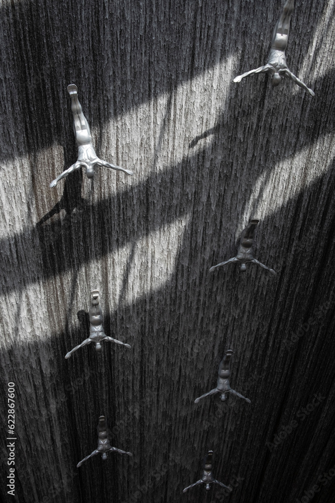 Silver fiberglass diving male sculptures installed to create jumping ...