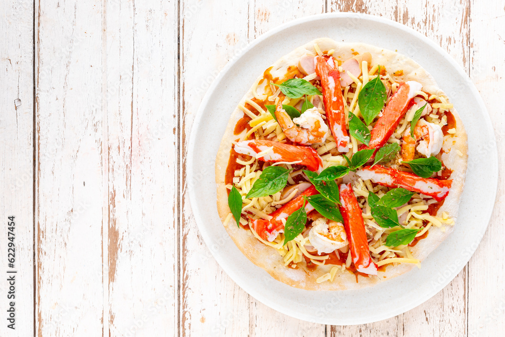raw pizza with tomato sauce, shrimp, crab stick, sausage, sweet basil ...