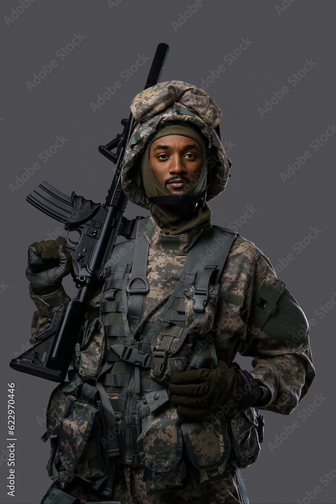 Dark skinned soldier in NATO uniform and helmet poses with a serious ...