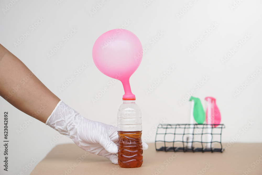 Foto de Hand holds pink inflated balloons on top of transparent test ...