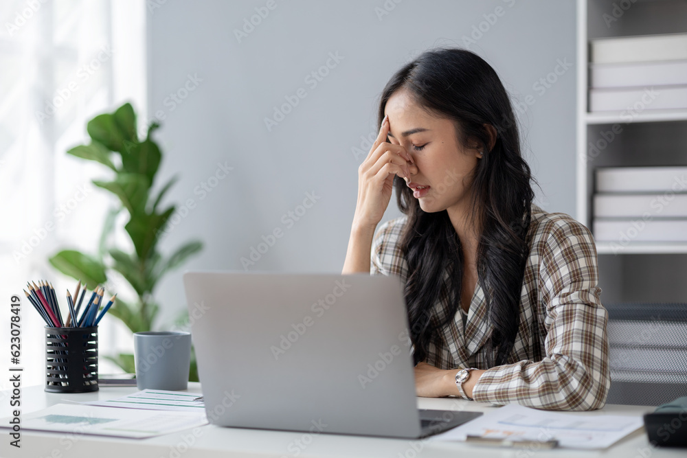 Beautiful asian woman suffering from stress due to working long hours ...