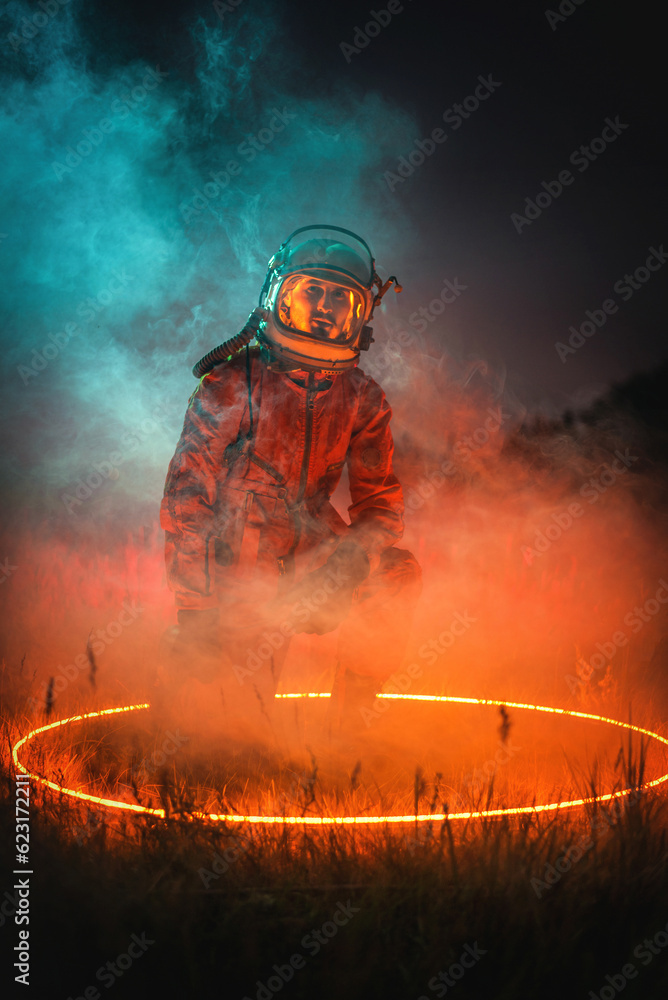 Spaceman in the spacesuit and helmet walks through portal on the alien ...