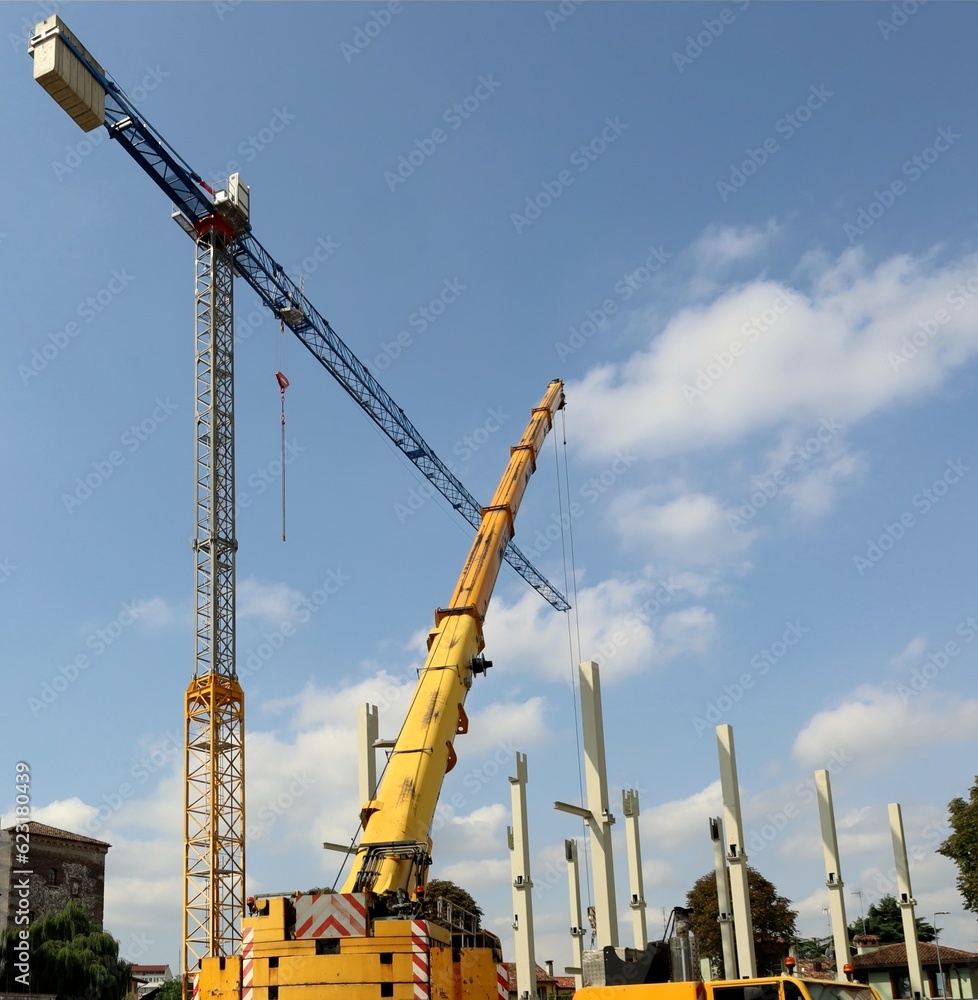Mobile crane installing the main pillars of the new building under ...