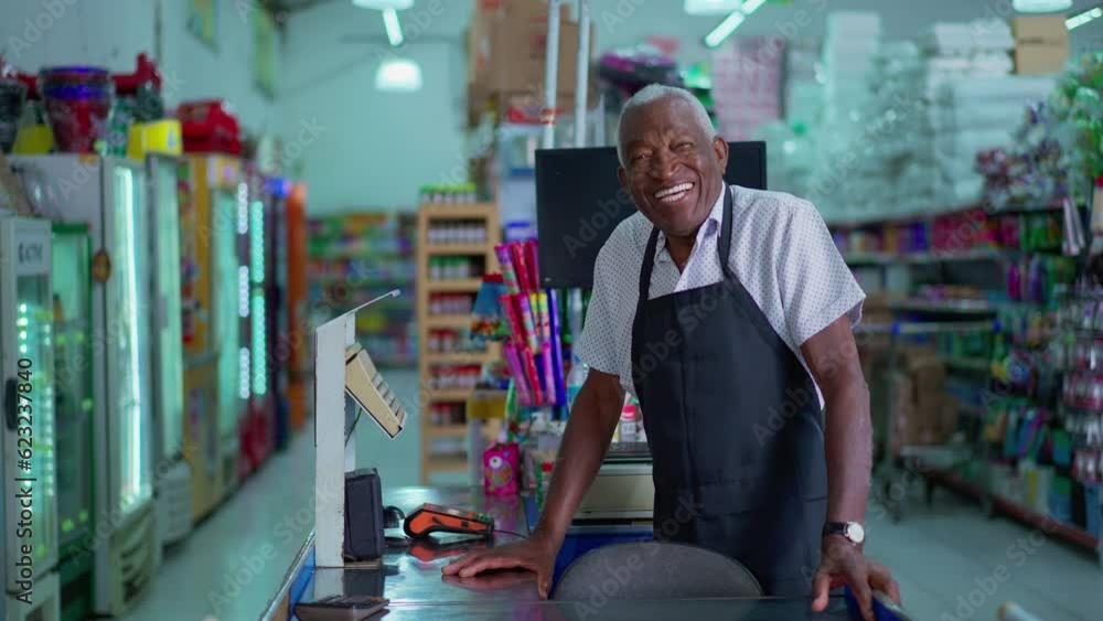 One happy black senior employee standing at supermarket cashier smiling ...