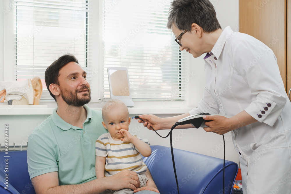 Child having hearing exam at otolaryngologist. Examining little patient ...