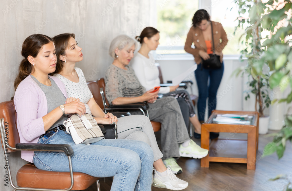 Young girl sitting in lobby of job center or employment office, waiting ...