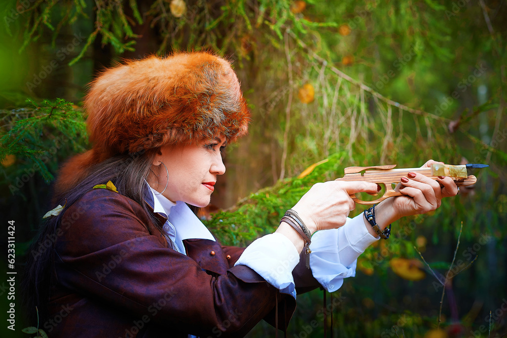 Girl in a leather jacket, a big red fox fur hat and with a crossbow in ...