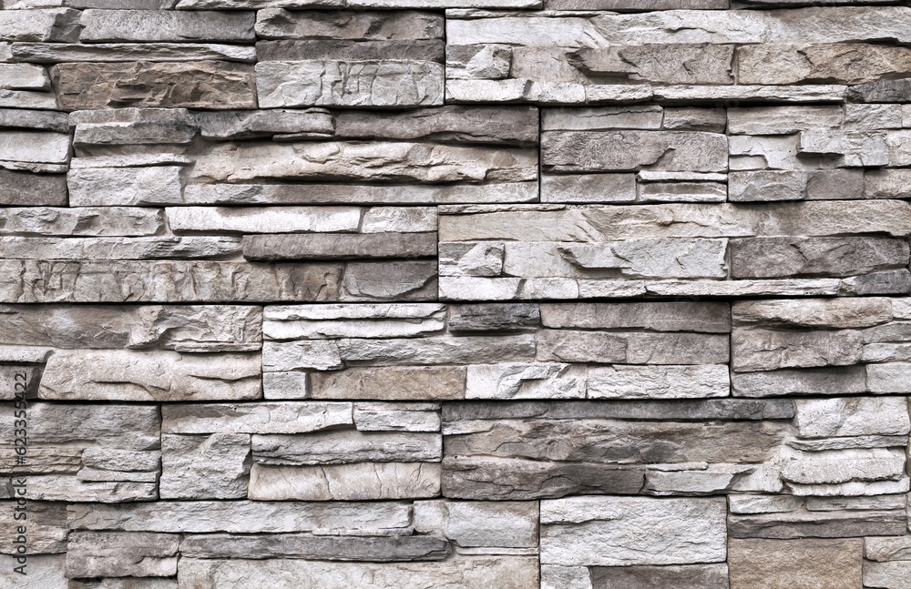 Stone cladding wall made of striped stacked slabs of gray rocks with ...