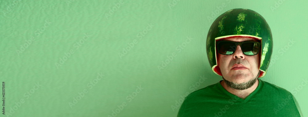 Crazy man wearing watermelon as helmet, hard hat on head and stylish ...