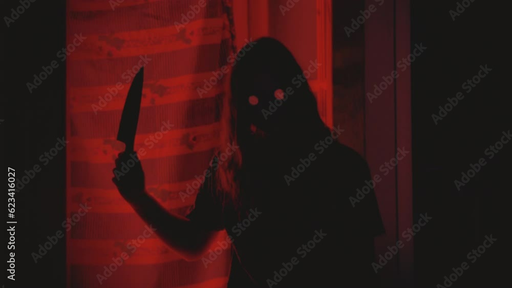 Zombie ghost girl with glowing eyes holding a big knife. Turning head ...