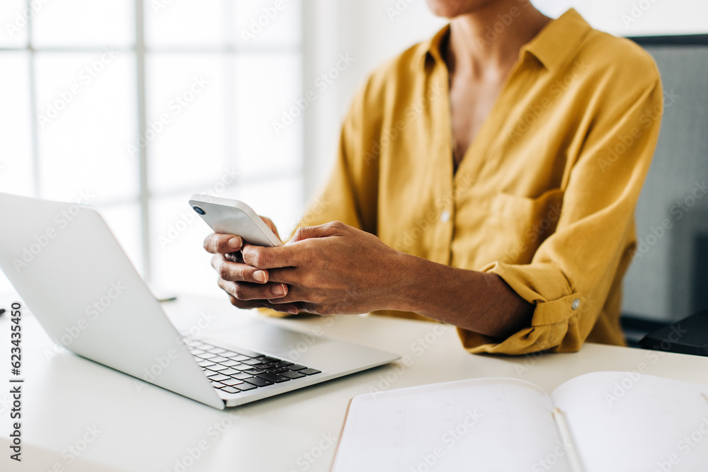 Using a mobile phone in the office. Business woman sending a text ...