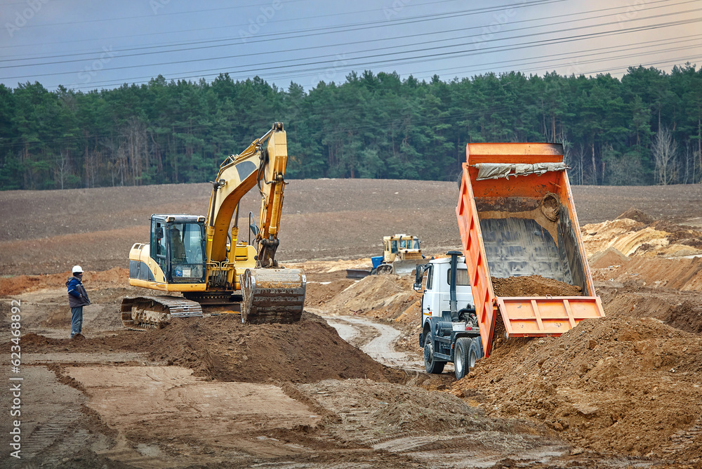 Dump truck unload sand and excavator digging trench at construction ...