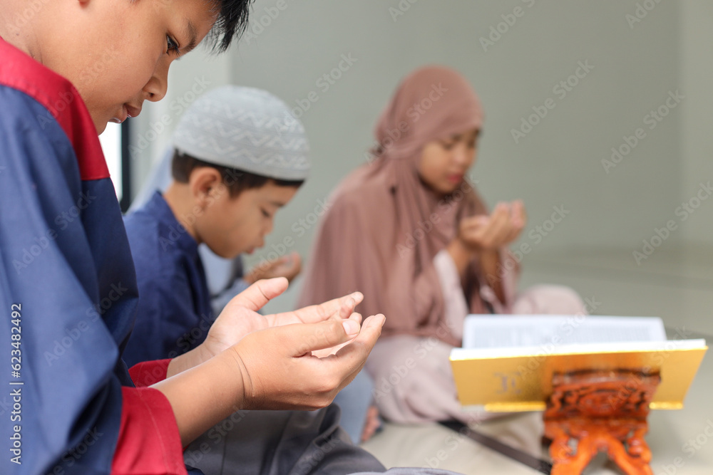 Asian muslim teen boy praying dua after or before reading Quran ...