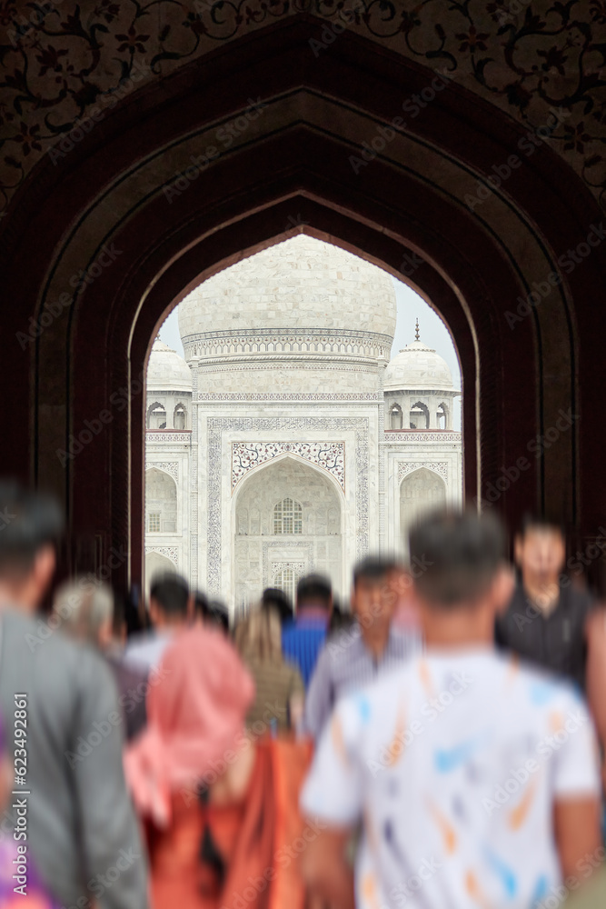 Archway of main gateway in Taj Mahal entrance with tourists silhouettes ...