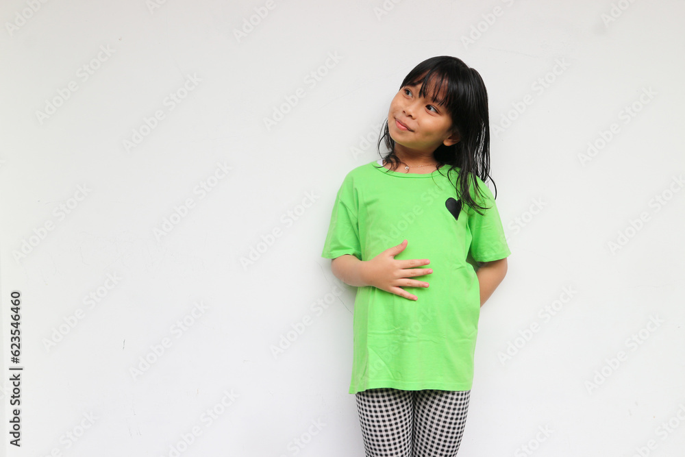 Comfort little girl, her hand holding on belly to feel satisfying food ...