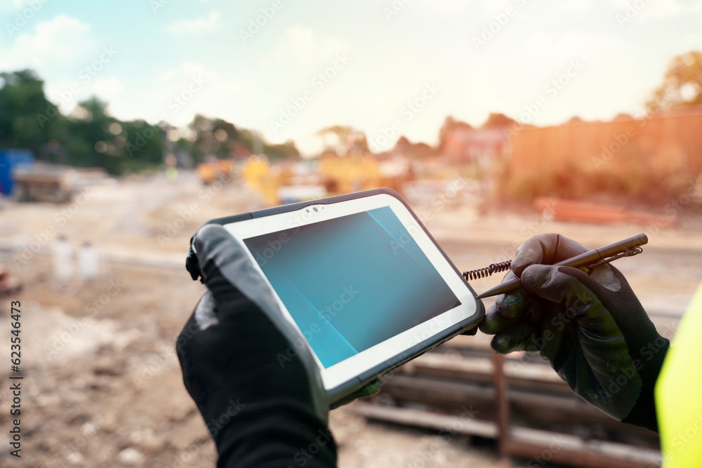 Site engineer surveyor using rugged tablet controller computer to ...