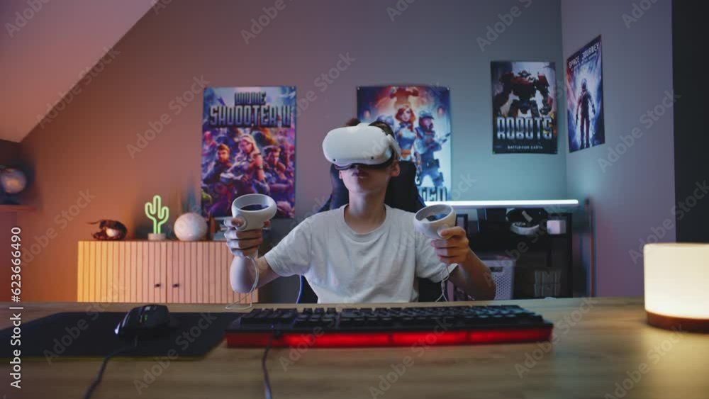 Young gamer in VR headset plays virtual online video game using ...