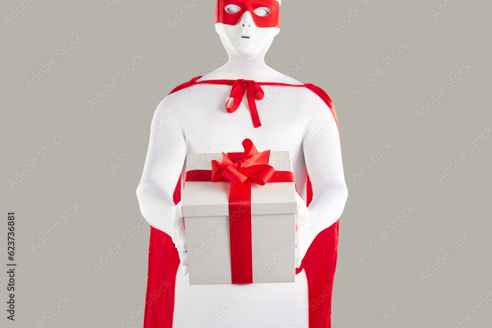 Superhero gives you a holiday present. Man disguised in a super hero ...