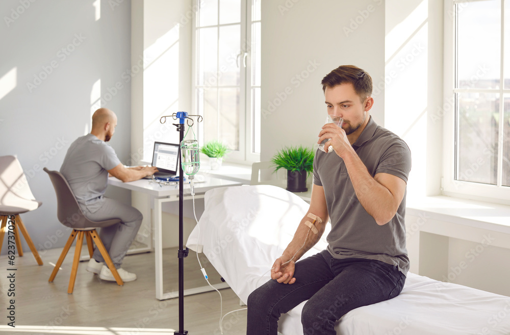 Male patient having intravenous treatment and rehydration therapy ...