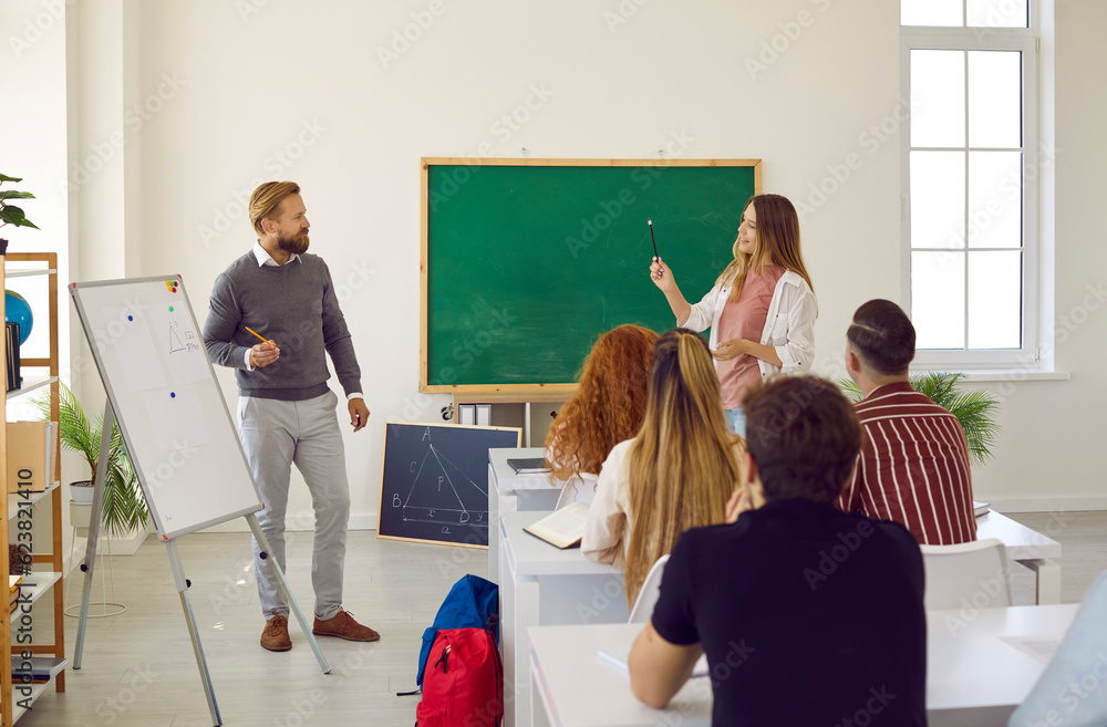 Student girl answering professor's question standing near desk in ...
